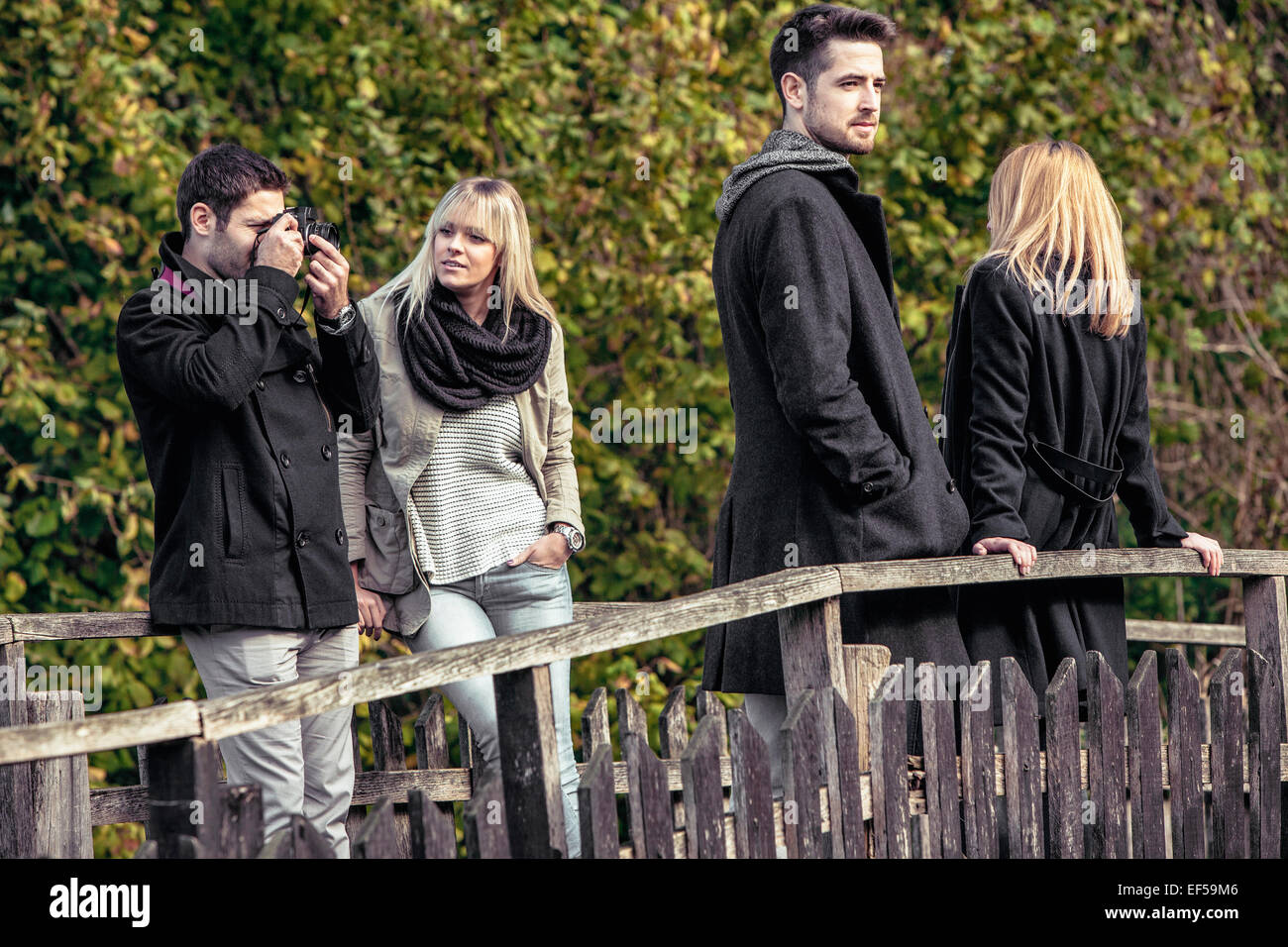 Group of friends standing on wooden bridge Stock Photo - Alamy