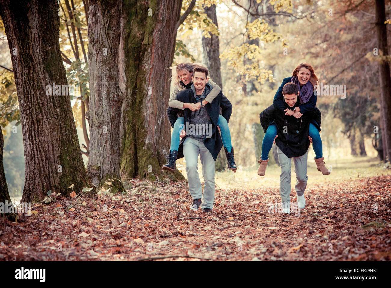 Men giving women a piggy back ride Stock Photo - Alamy