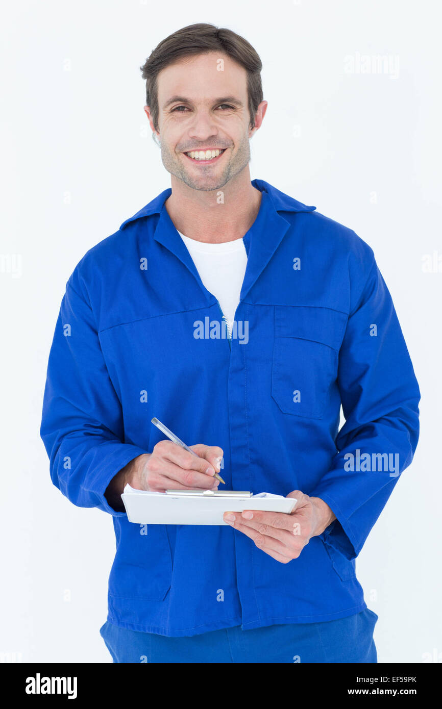 Confident of mechanic writing notes on clipboard Stock Photo - Alamy