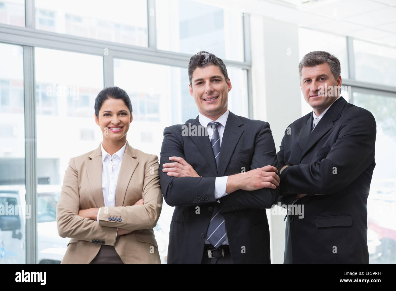 Smiling business team standing with arms crossed Stock Photo - Alamy
