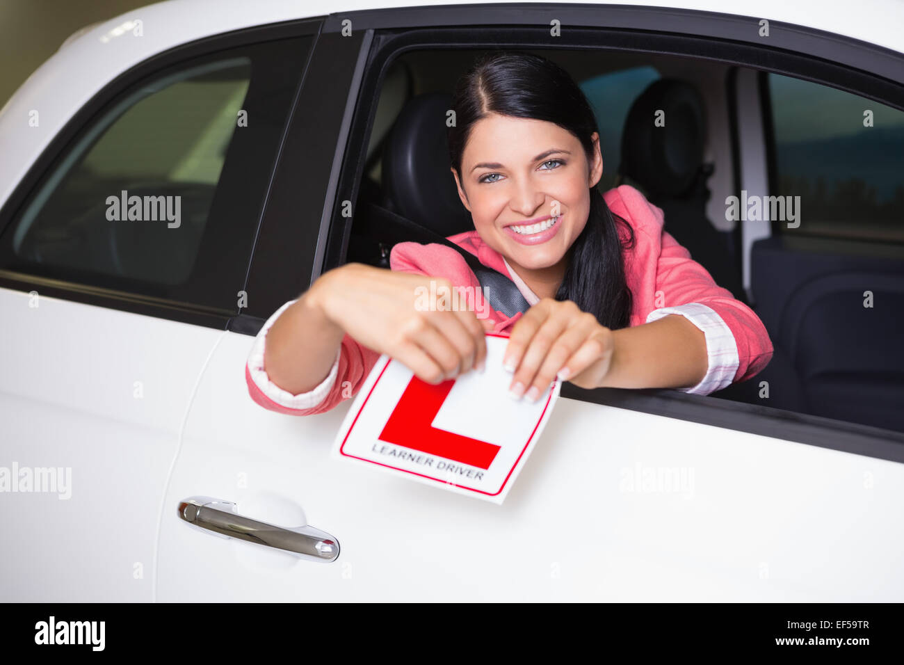 Cheerful female driver tearing up her L sign Stock Photo - Alamy
