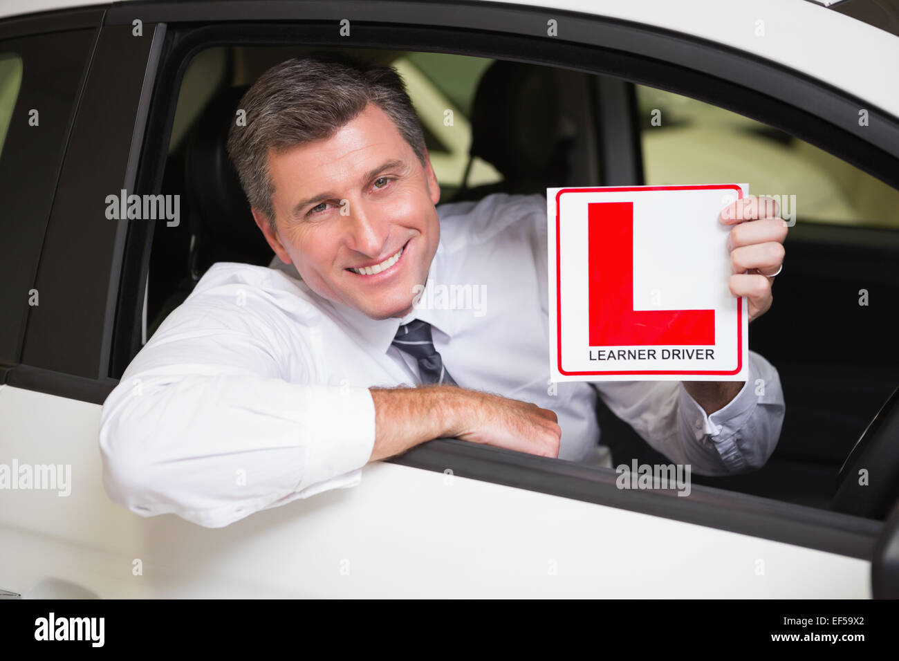 Man holding a learner driver sign sitting behind the wheel Stock Photo ...