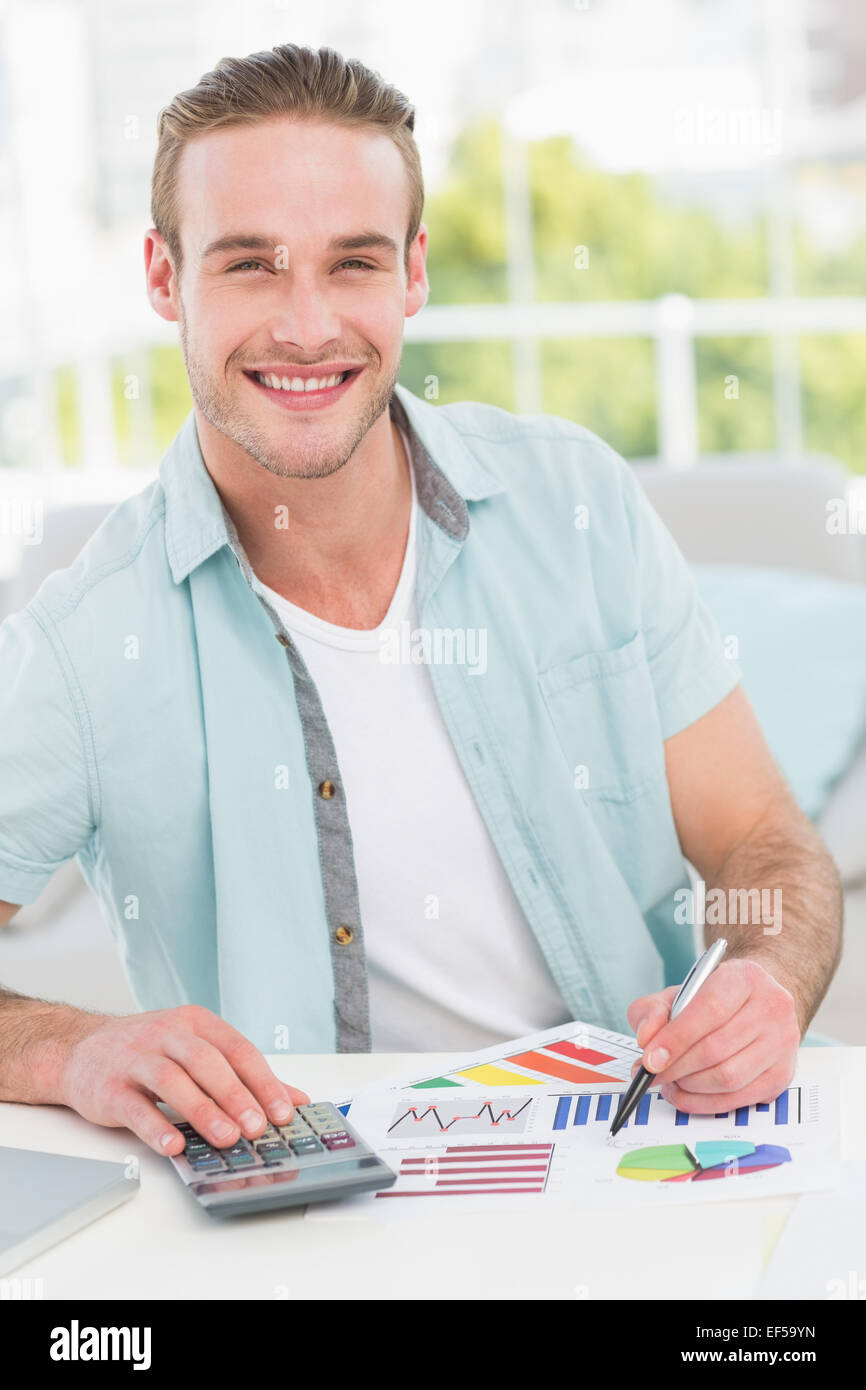 Smiling businessman working on measuring graph at his desk Stock Photo ...
