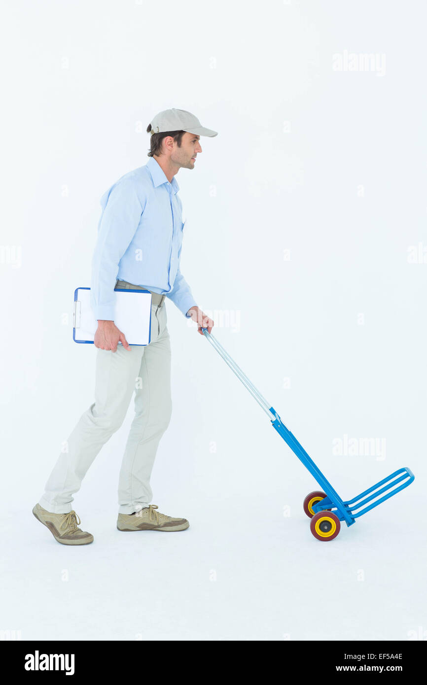 Delivery man pushing empty trolley Stock Photo - Alamy