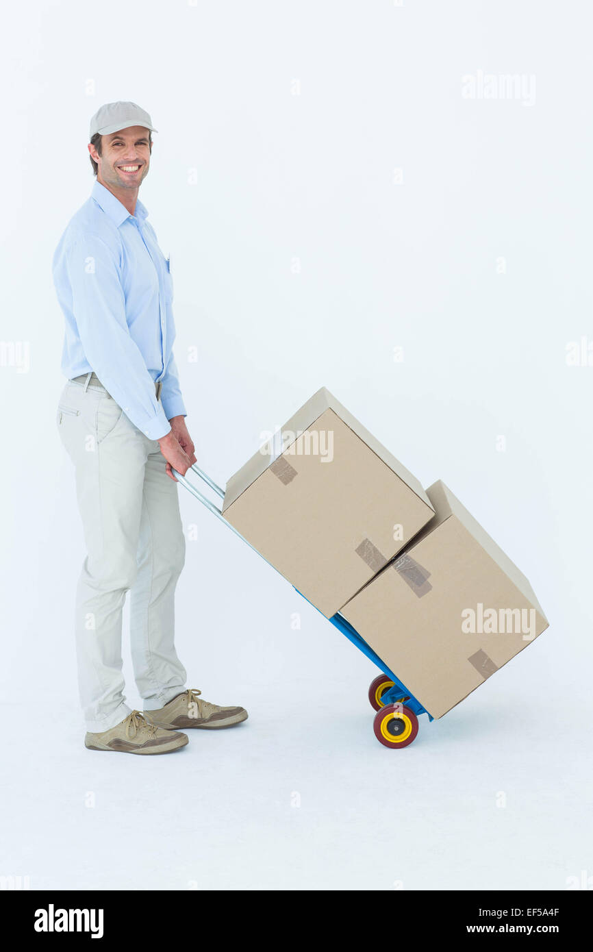 Confident delivery man pushing trolley of cardboard boxes Stock Photo ...
