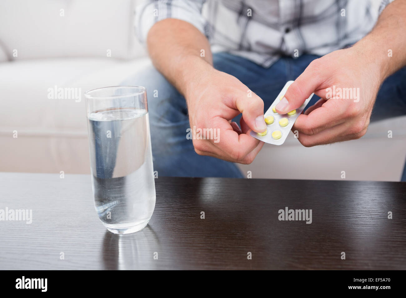 Hungover man with his medicine laid out on coffee table Stock Photo - Alamy