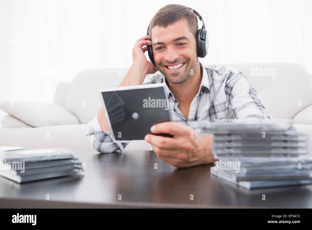 Smiling man listening to cds Stock Photo - Alamy