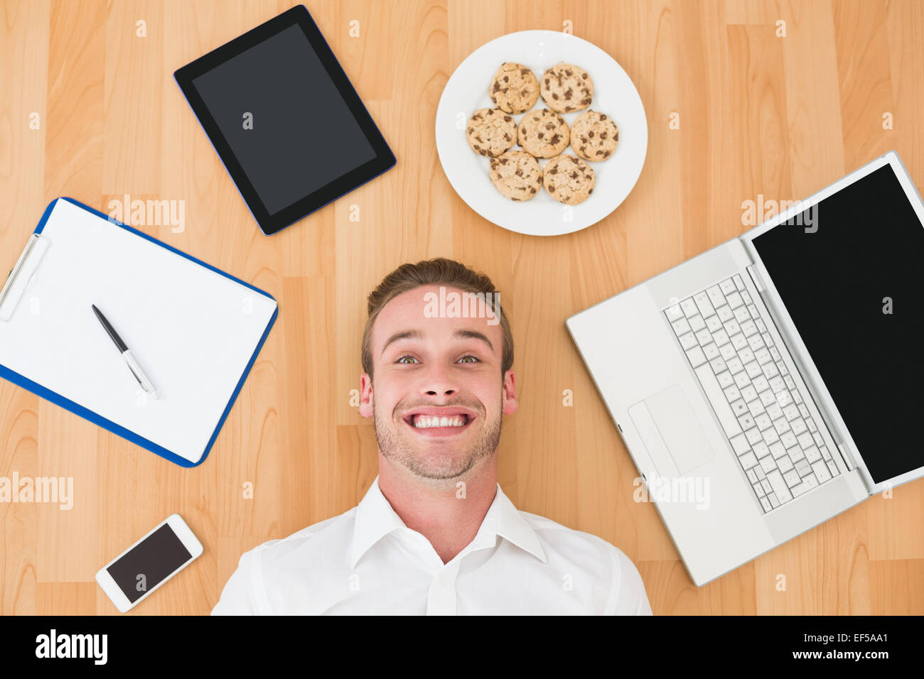 Man lying on floor surrounded by various objects at home Stock Photo ...