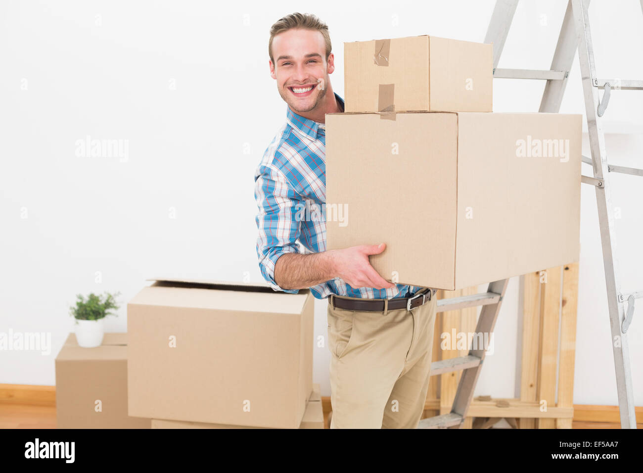 Smiling man carrying cardboard moving boxes Stock Photo - Alamy