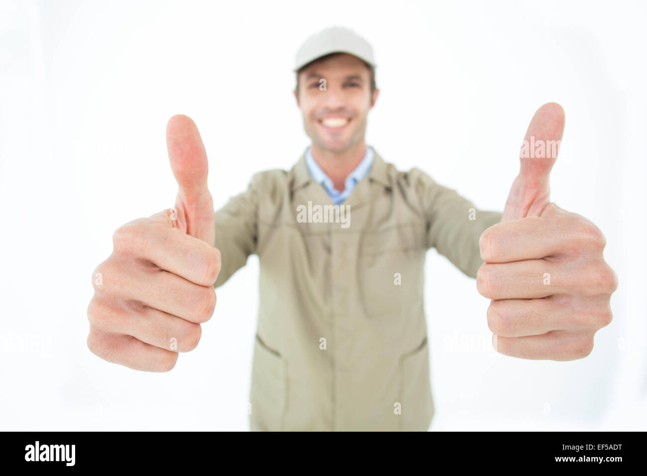 Smiling delivery man showing thumbs up Stock Photo - Alamy
