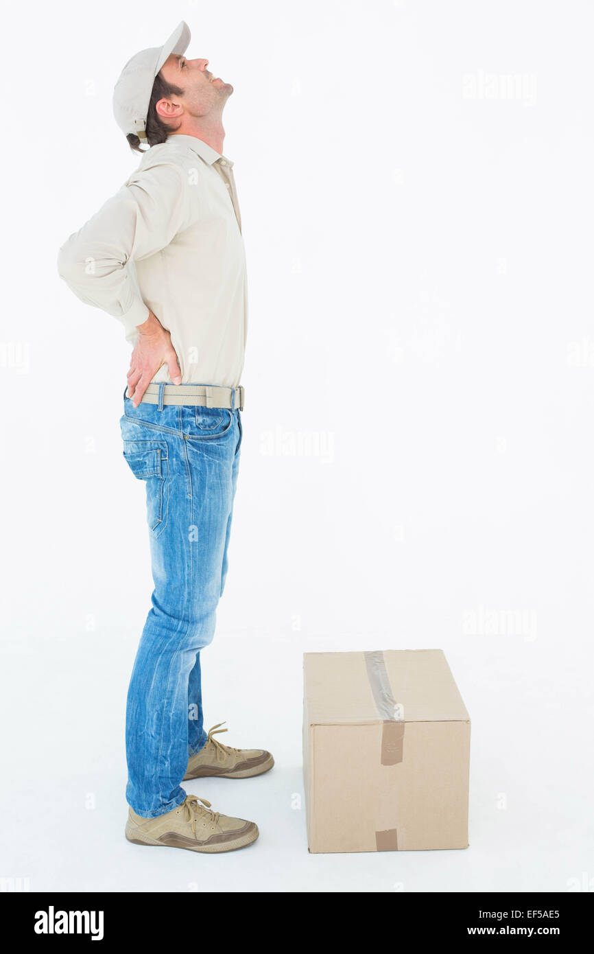 Delivery man suffering from back pain standing by box Stock Photo - Alamy
