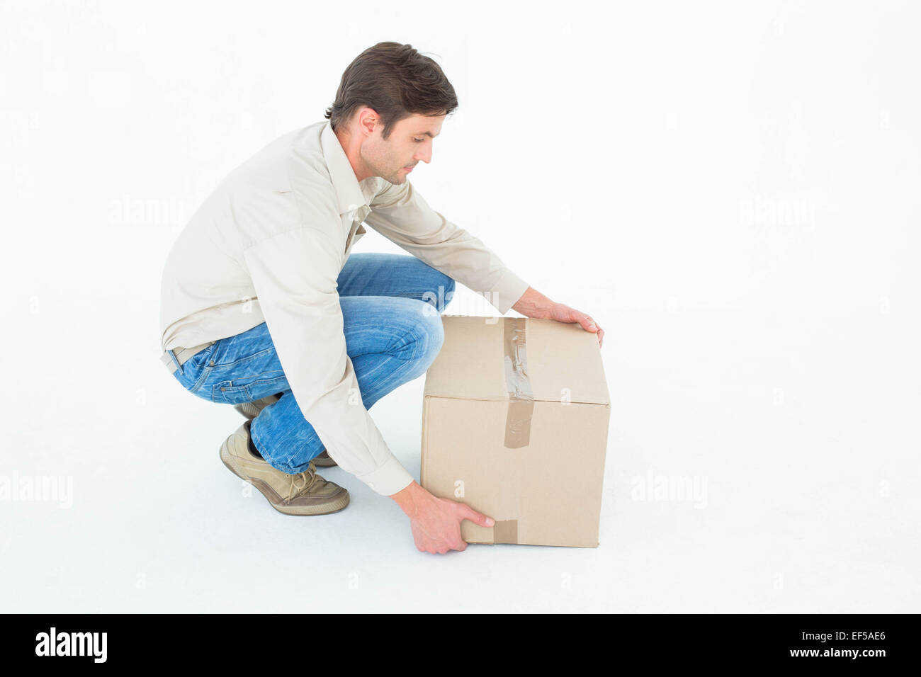 Delivery man picking cardboard box Stock Photo - Alamy