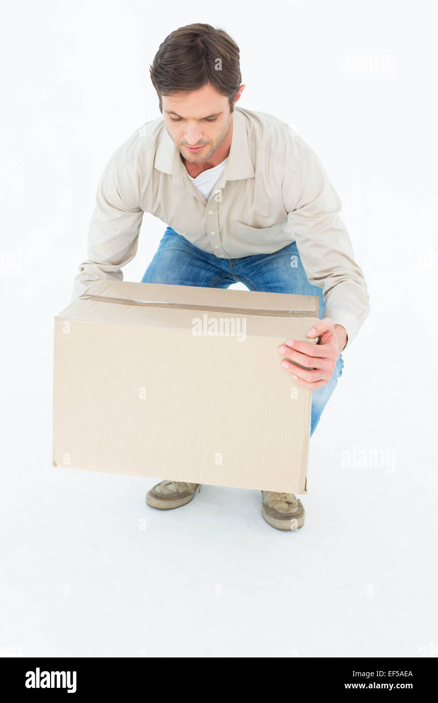 Delivery man picking cardboard box Stock Photo - Alamy