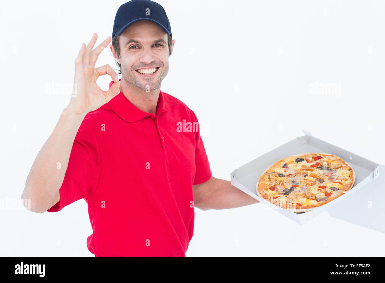 Delivery man gesturing okay while holding fresh pizza Stock Photo - Alamy