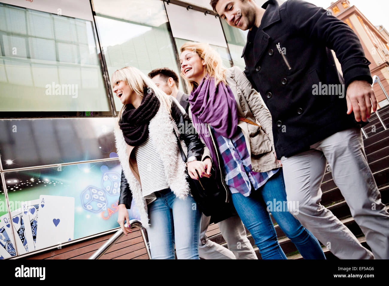 Group of friends walking down steps in town Stock Photo - Alamy