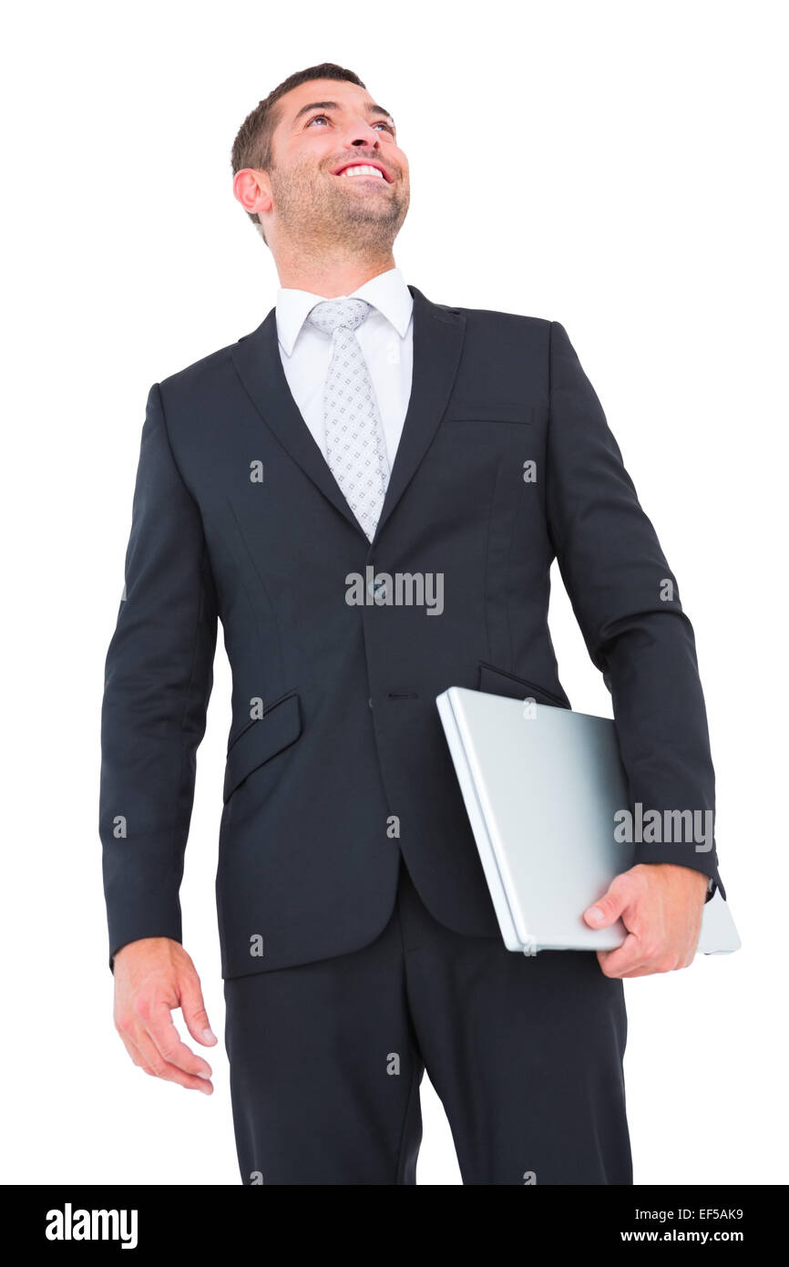 Businessman looking up holding laptop Stock Photo - Alamy