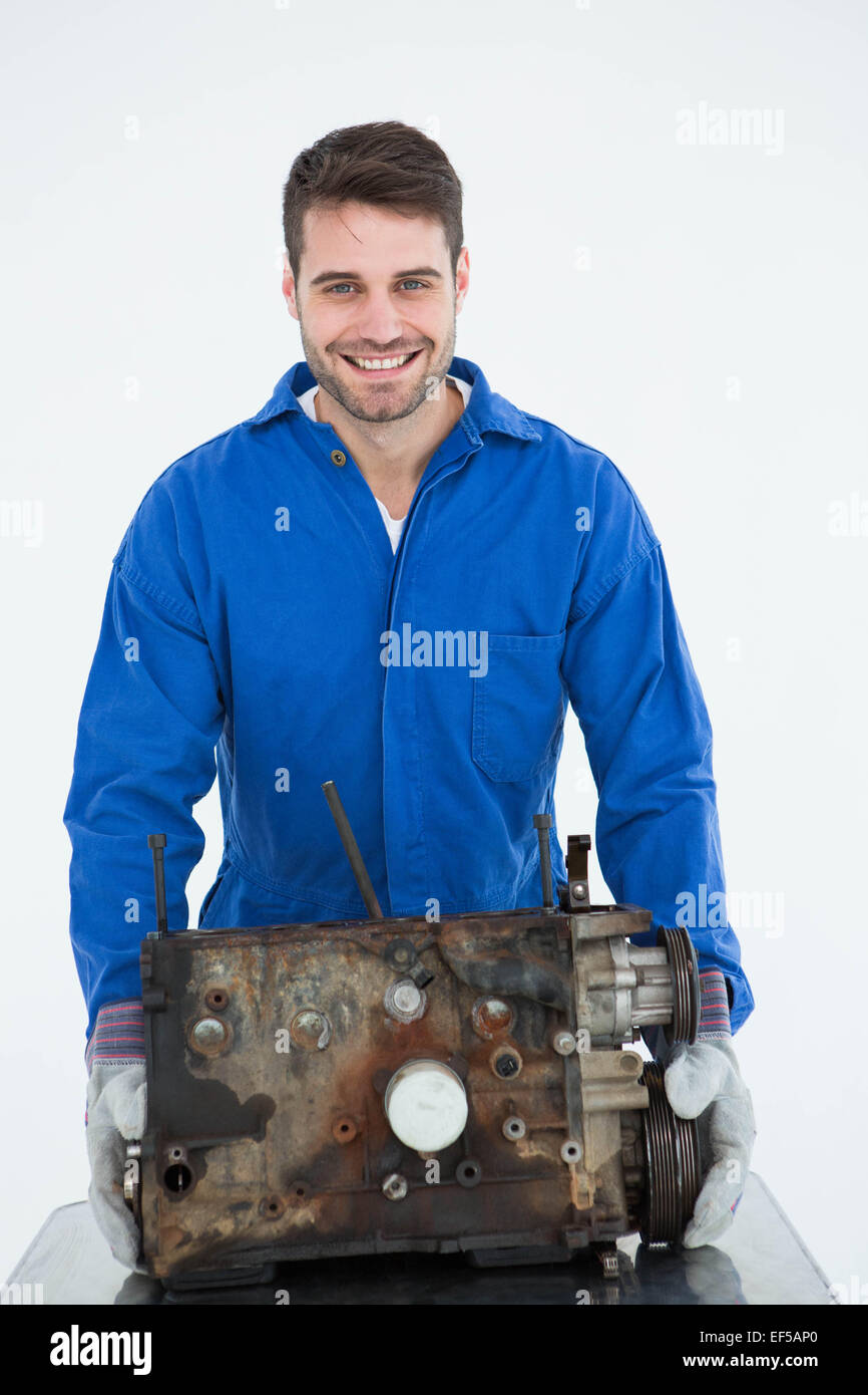 Smiling male machanic carrying old car engine Stock Photo - Alamy