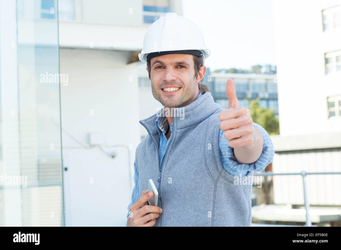 Handsome male architect gesturing thumbs up Stock Photo - Alamy