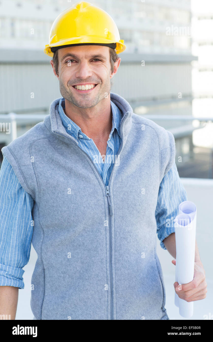 Smiling male architect holding blueprint Stock Photo - Alamy