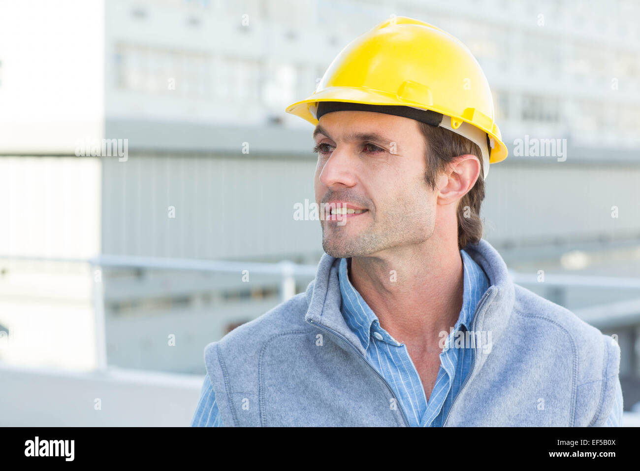 Thoughtful architect wearing yellow hard hat Stock Photo - Alamy
