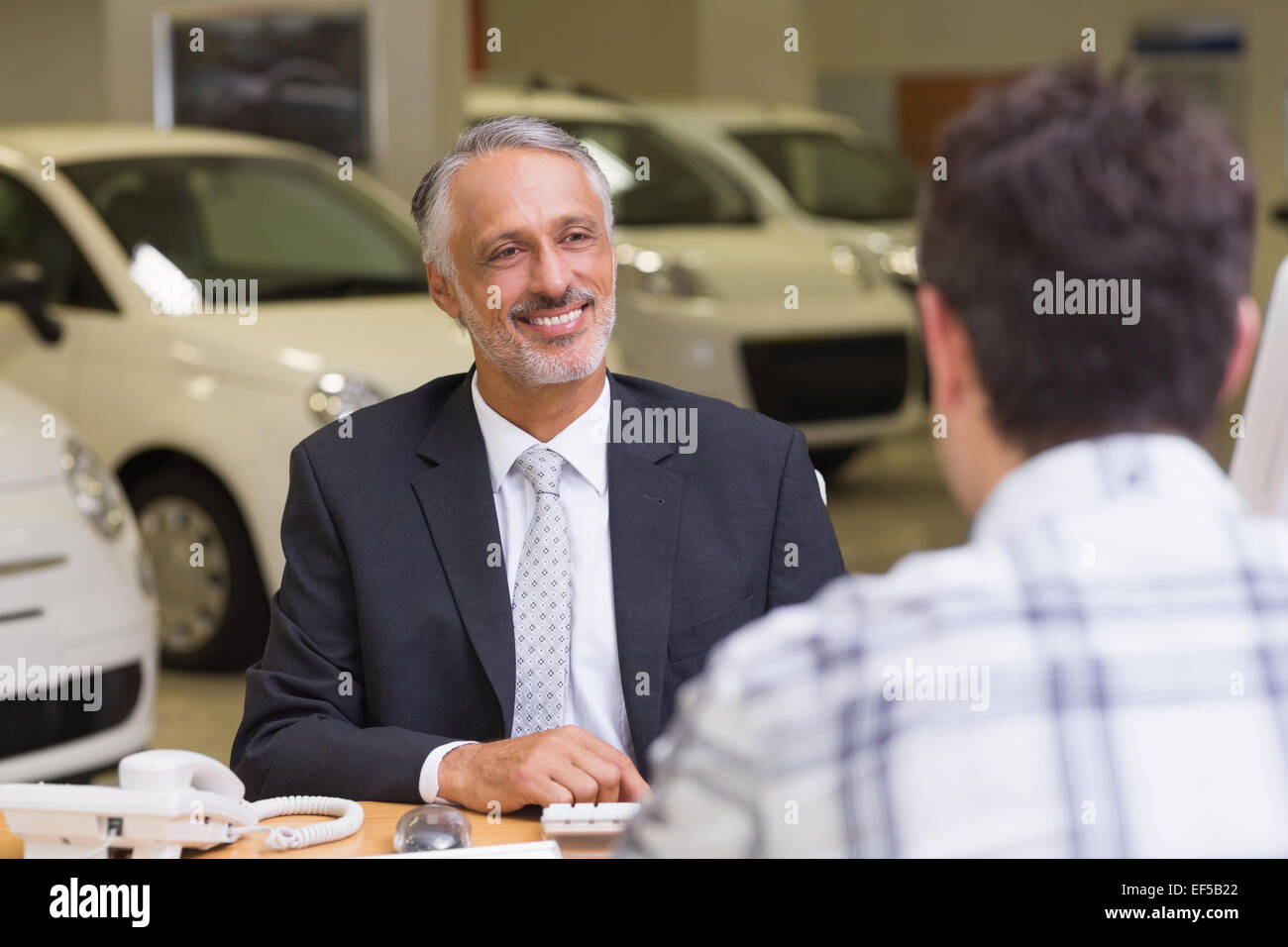 Salesman speaking with a client Stock Photo - Alamy