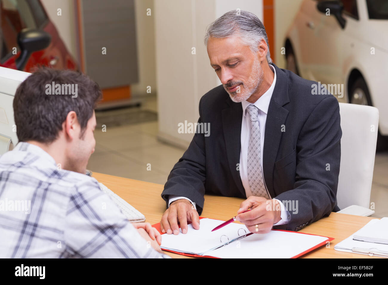Salesman showing client where to sign the deal Stock Photo - Alamy