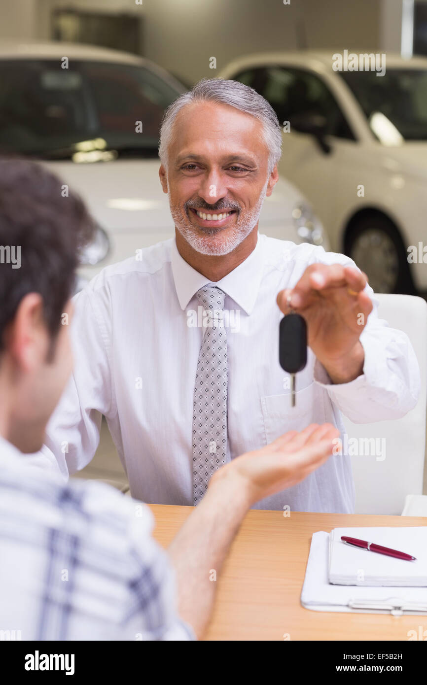 Smiling salesman giving a customer car keys Stock Photo - Alamy