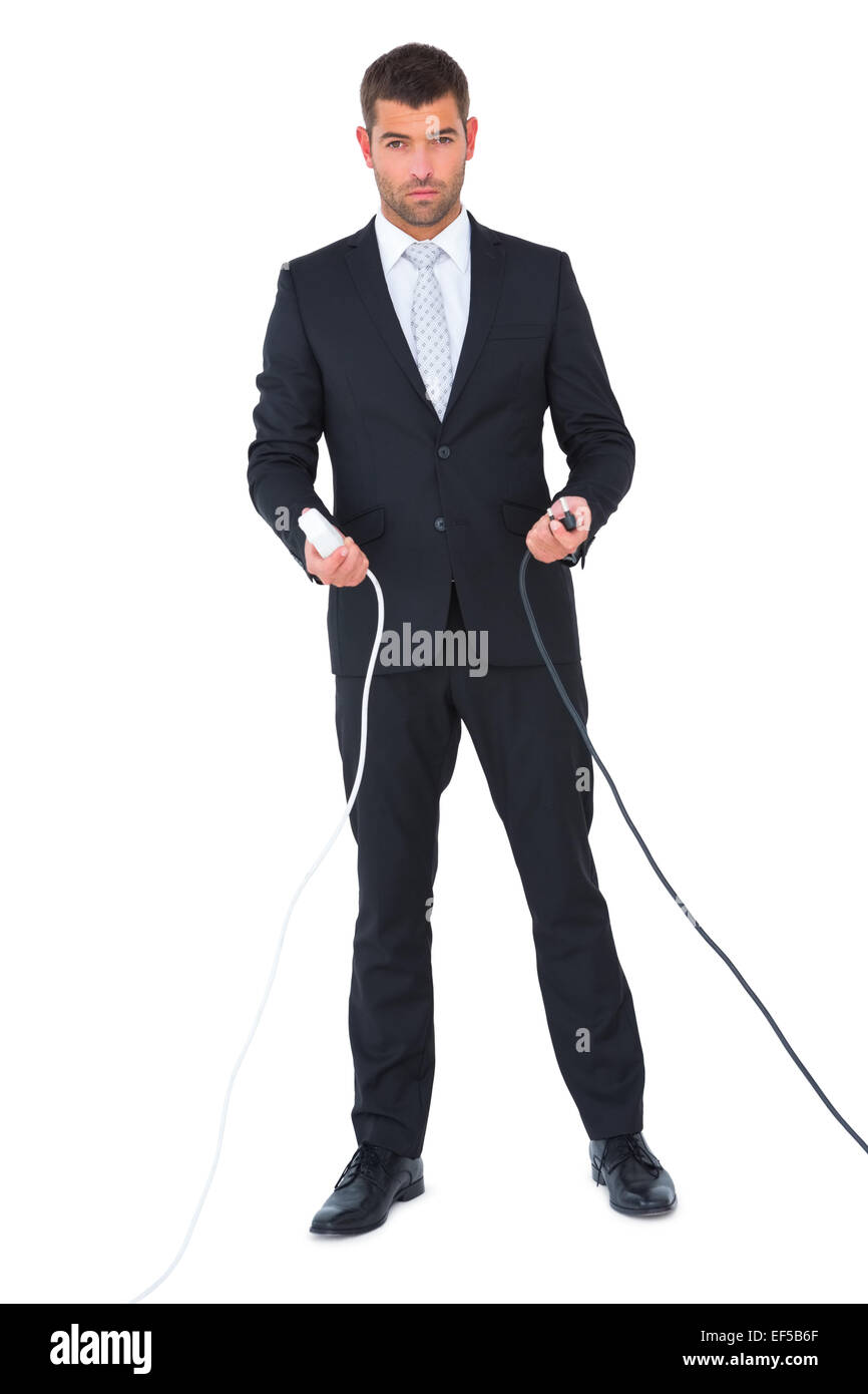 Serious businessman holding cables to connect Stock Photo - Alamy