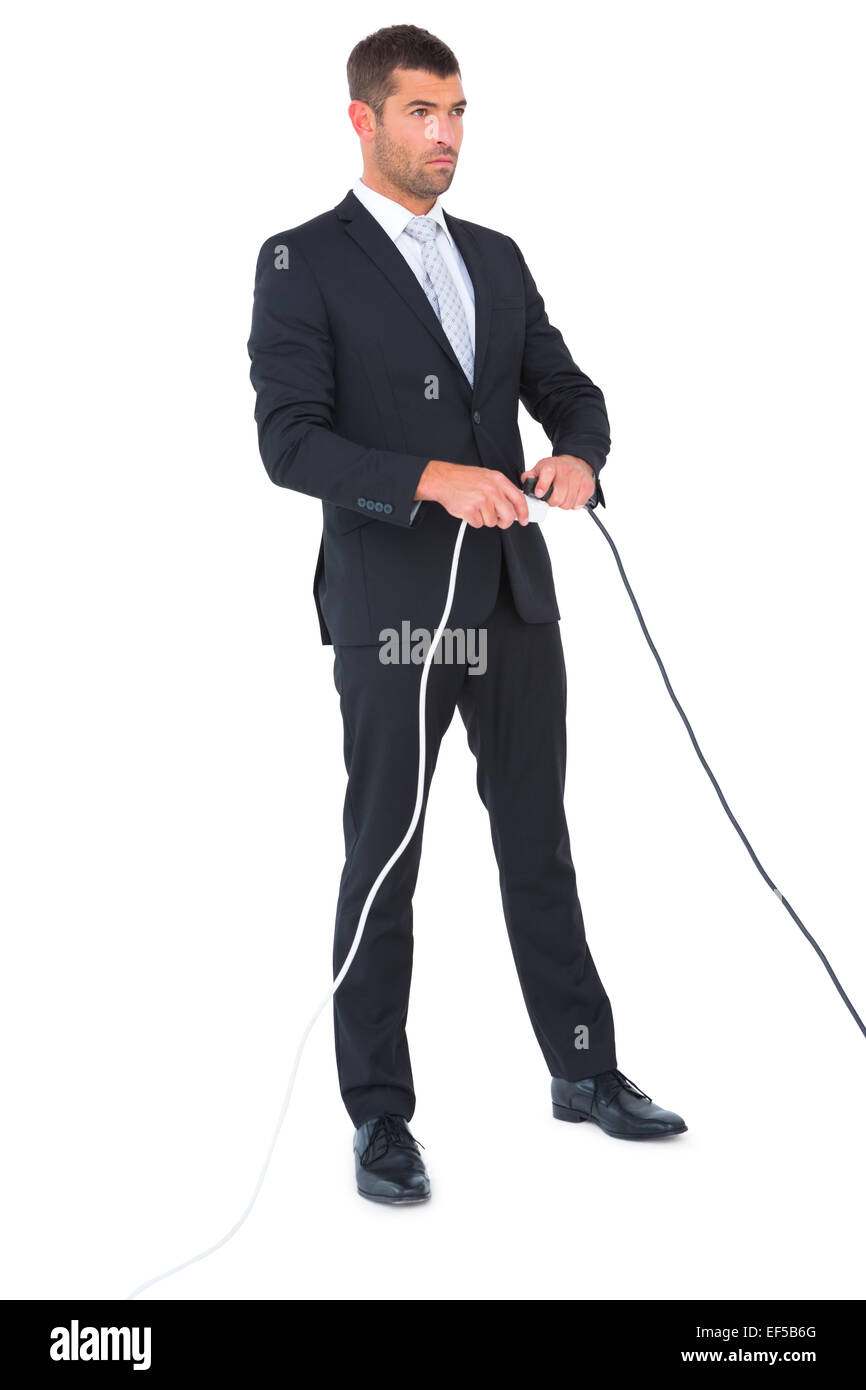 Serious businessman connecting a plug Stock Photo - Alamy