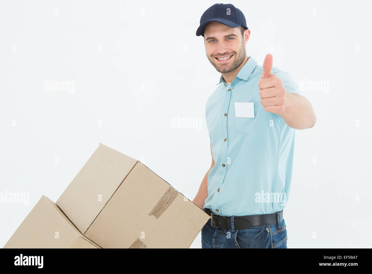 Delivery man with cardboard boxes gesturing thumbs up Stock Photo - Alamy
