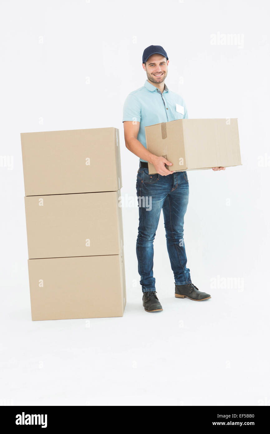 Courier man carrying cardboard box Stock Photo - Alamy