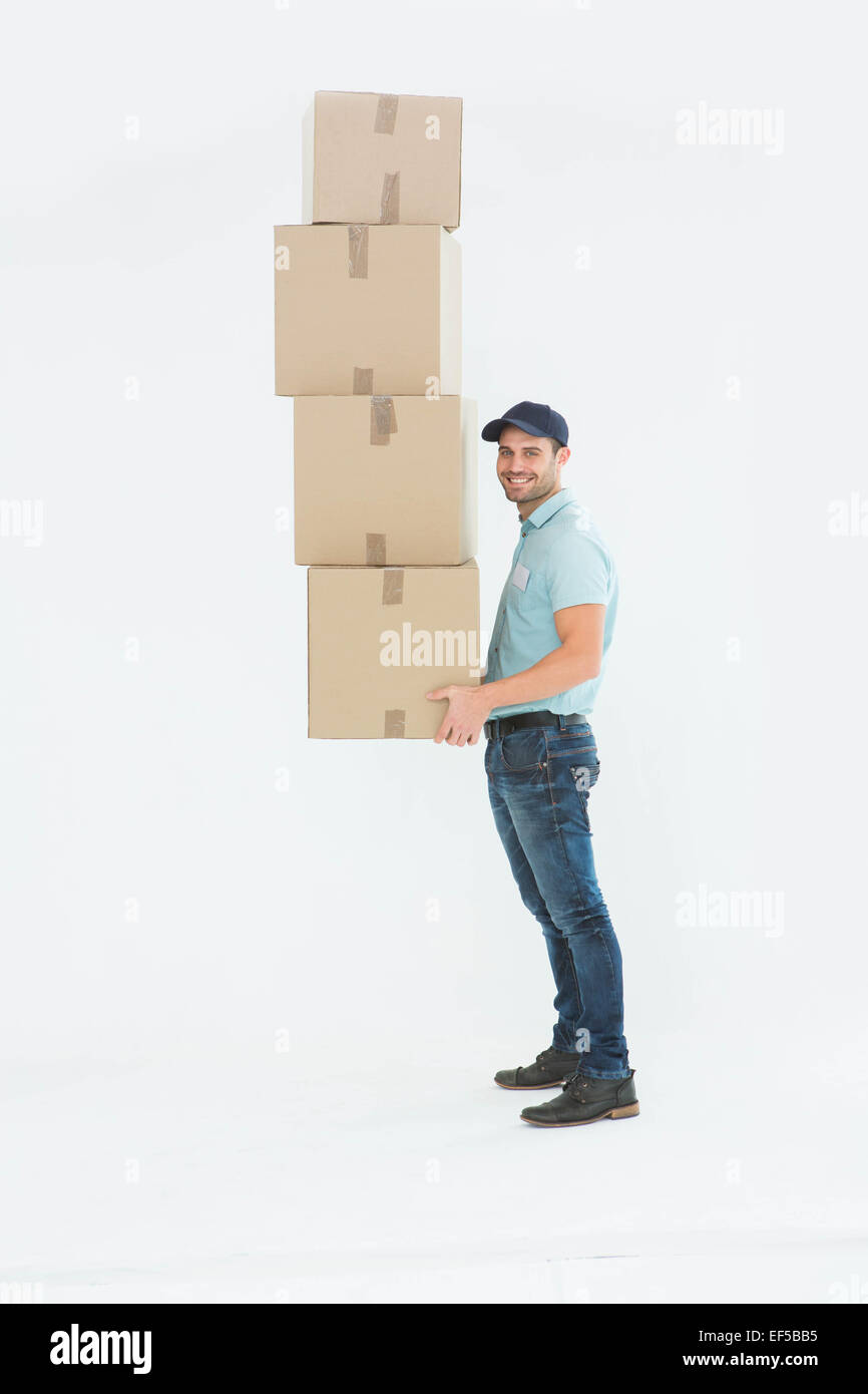 Confident delivery man carrying stack of boxes Stock Photo - Alamy