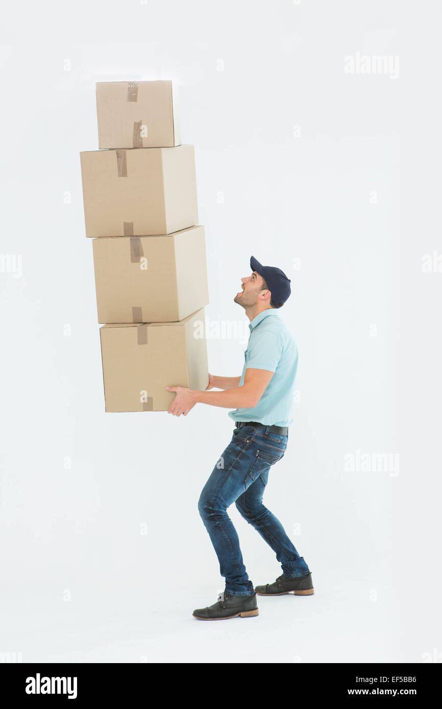 Shocked delivery man carrying stack of boxes Stock Photo - Alamy