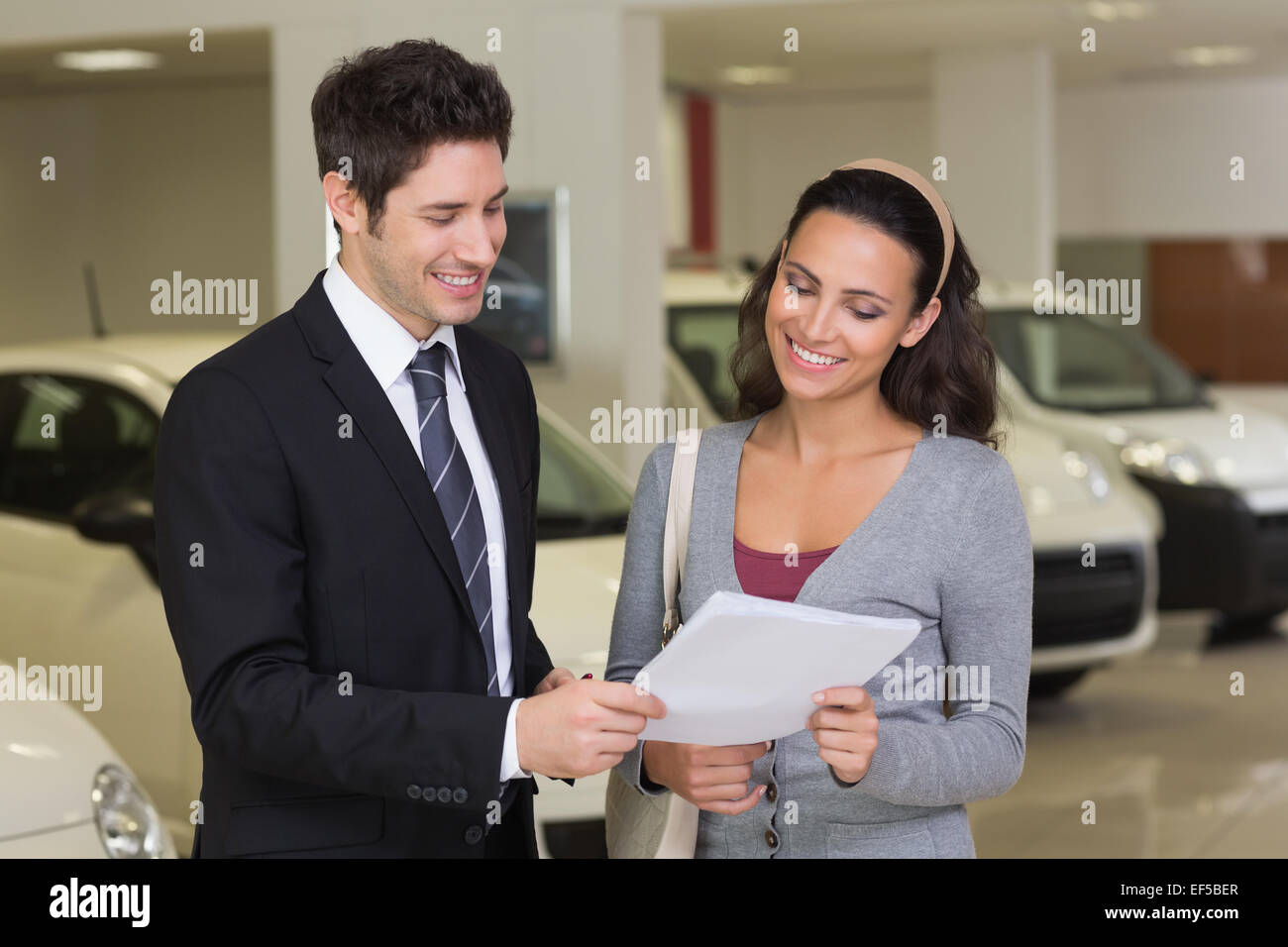Salesperson showing clipboard to sign to customer Stock Photo - Alamy
