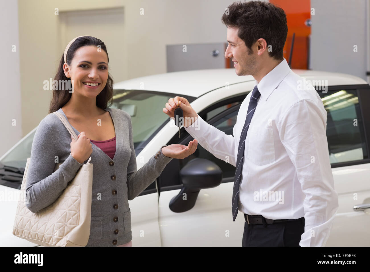 Smiling businessman giving car key to happy customer Stock Photo - Alamy