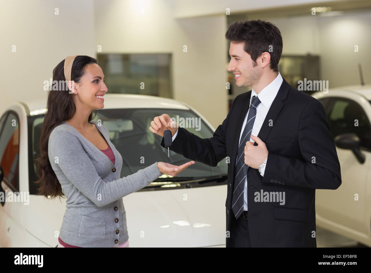 Smiling businessman giving car key to happy customer Stock Photo - Alamy