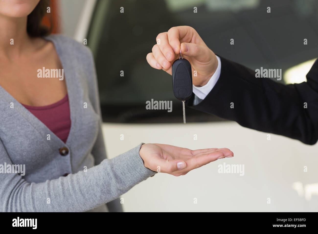 Smiling businessman giving car key to happy customer Stock Photo - Alamy