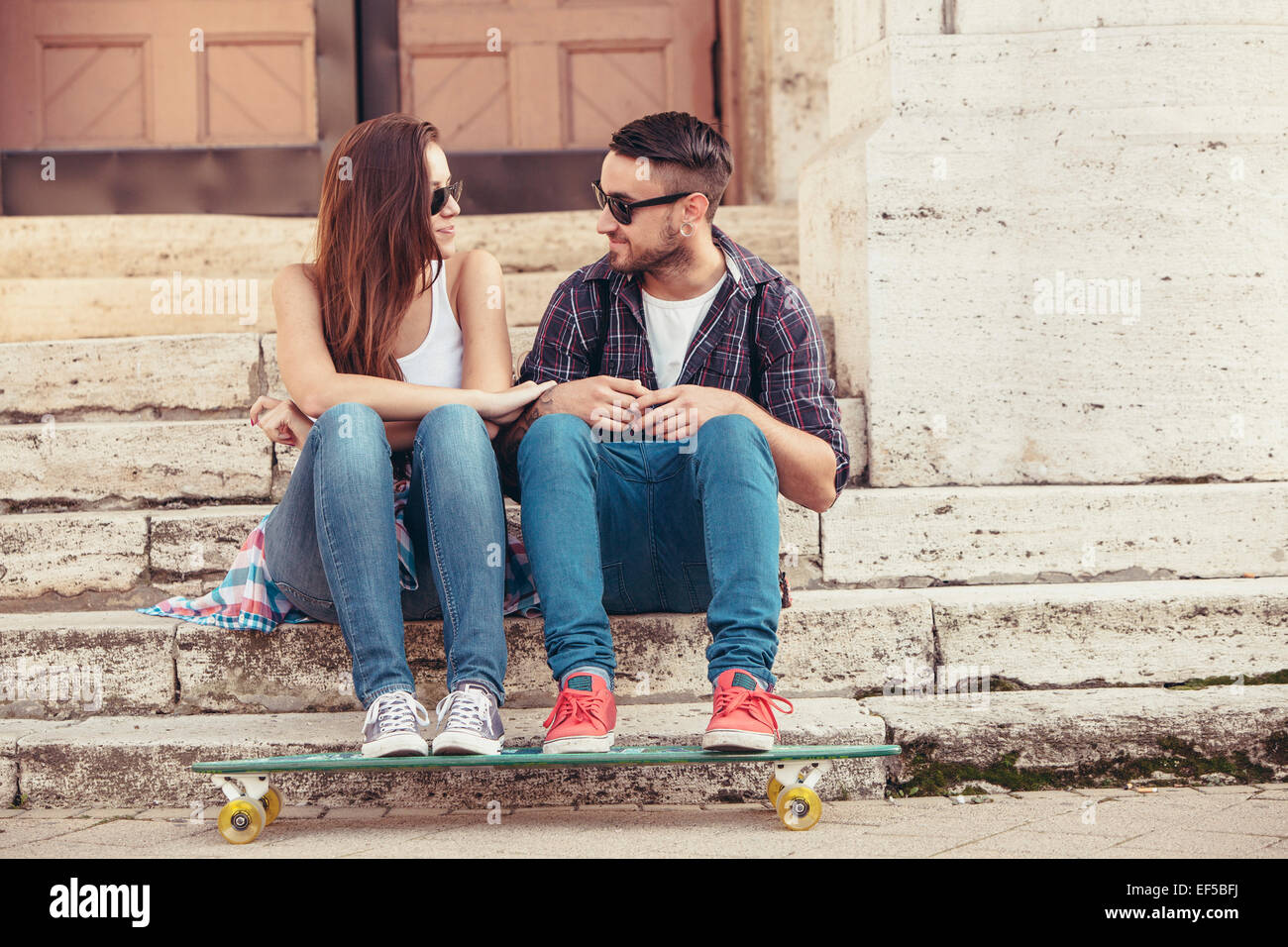 Young couple with skateboard taking a break Stock Photo - Alamy