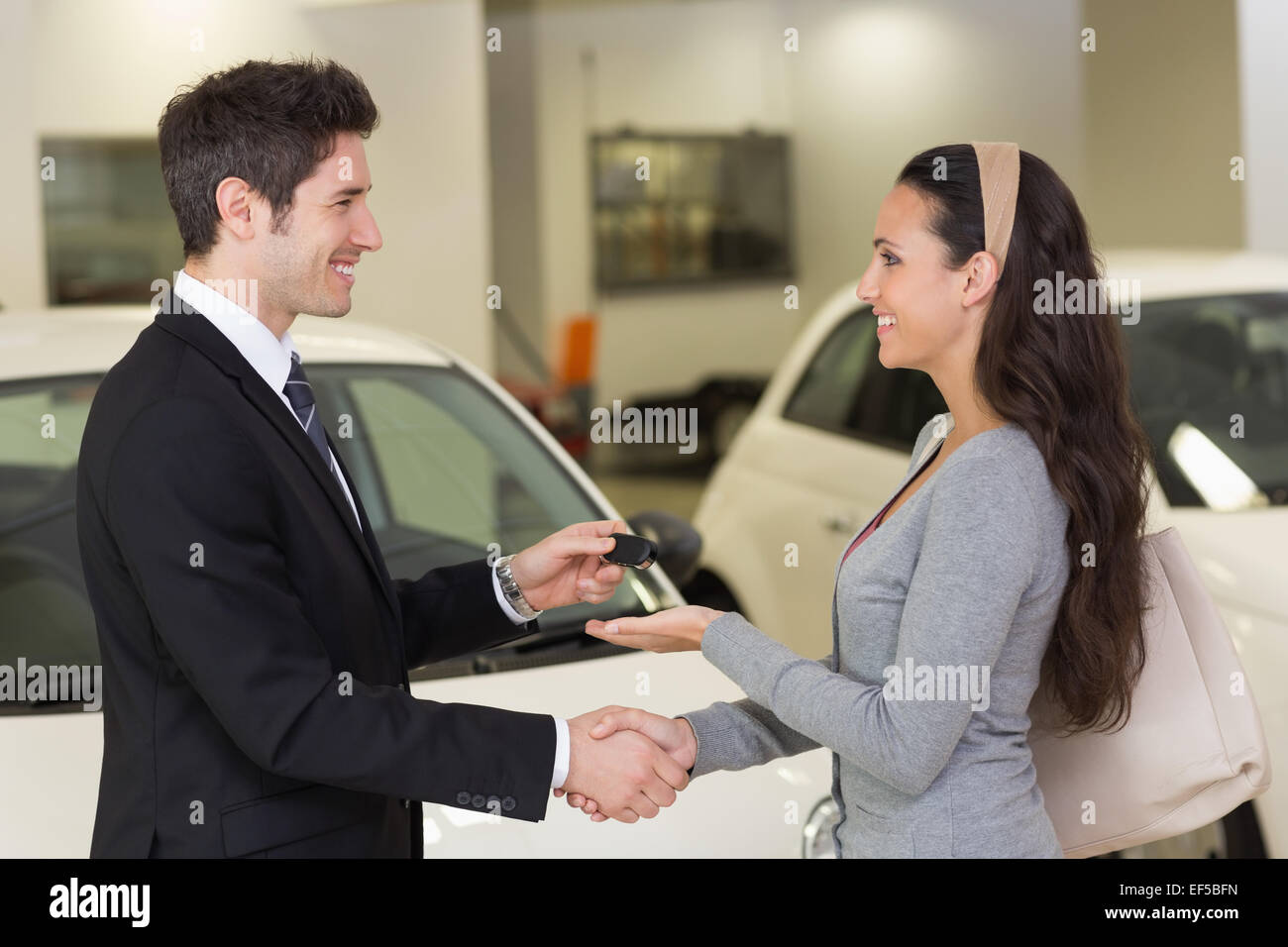Businessman giving car key while shaking a customer hand Stock Photo ...