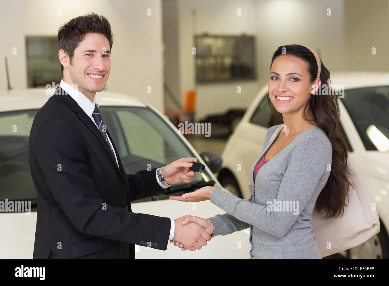 Businessman giving car key while shaking a customer hand Stock Photo ...