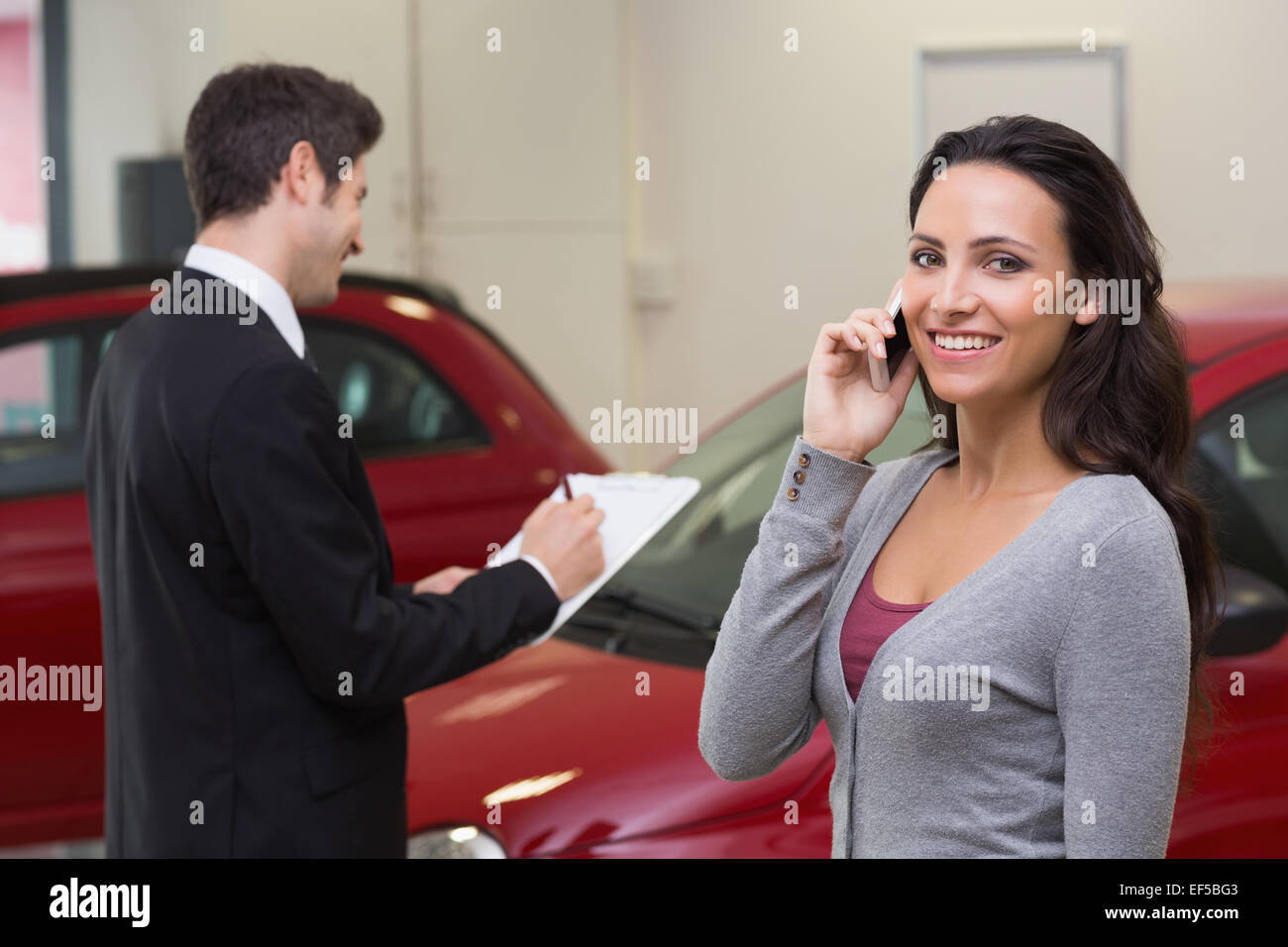 Smiling woman calling someone with her mobile phone Stock Photo - Alamy