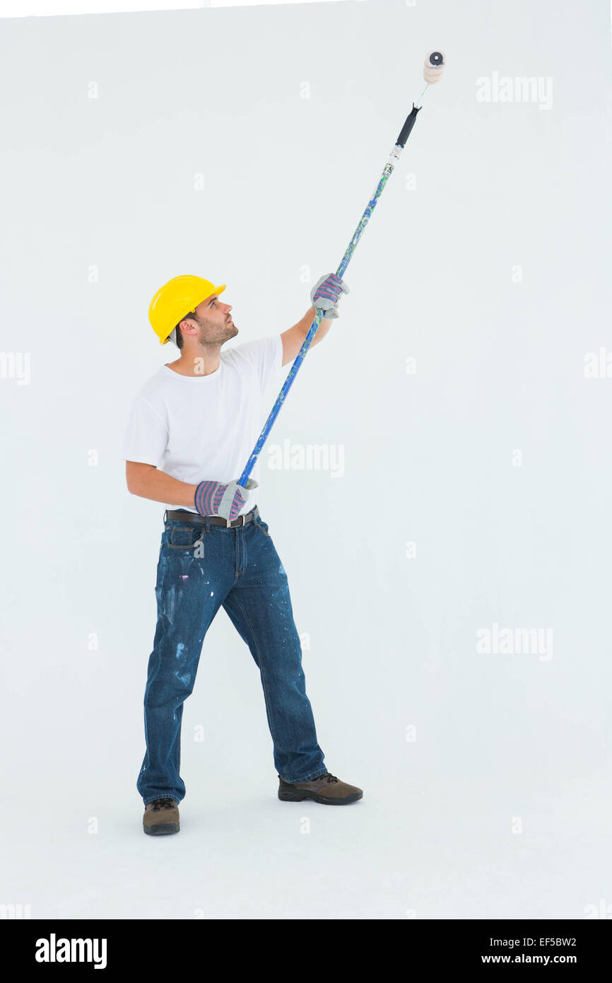 Man painting with roller on white background Stock Photo - Alamy