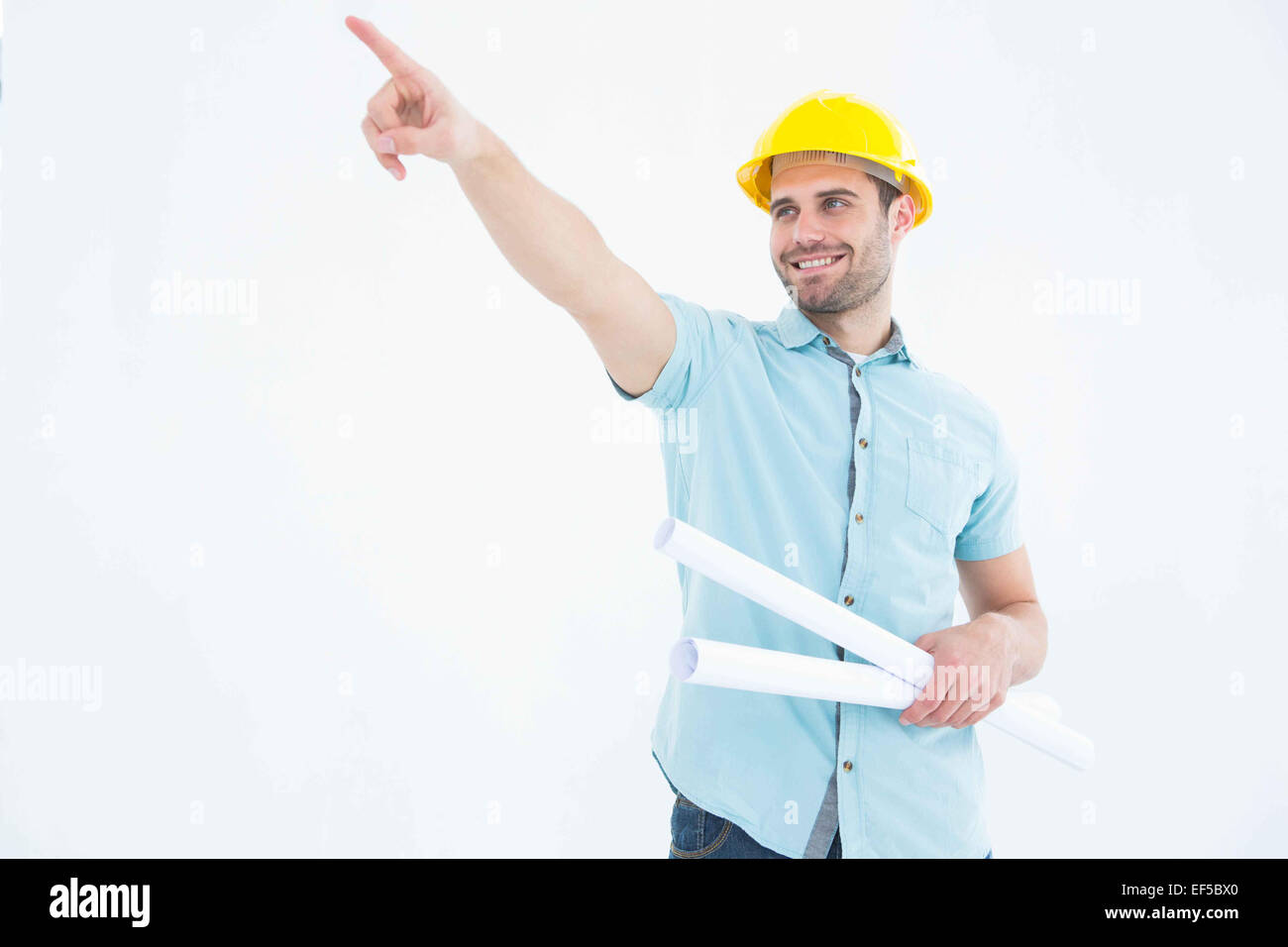 Male architect with blueprints pointing away Stock Photo - Alamy