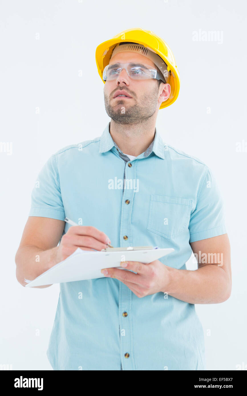 Supervisor looking away while writing on clipboard Stock Photo - Alamy
