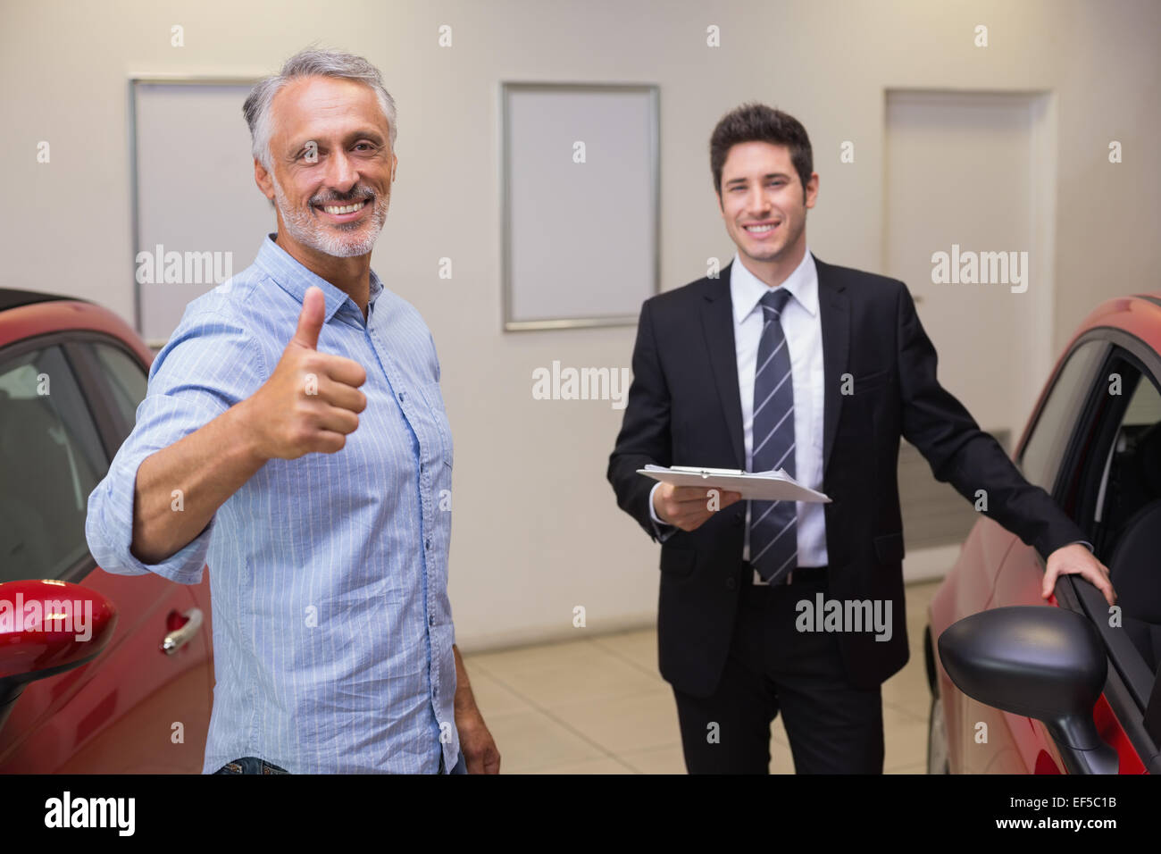 Smiling customer giving thumbs up Stock Photo - Alamy