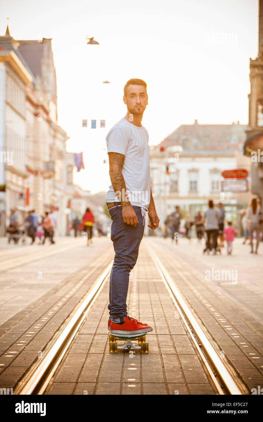Young man skateboarding on city street Stock Photo - Alamy