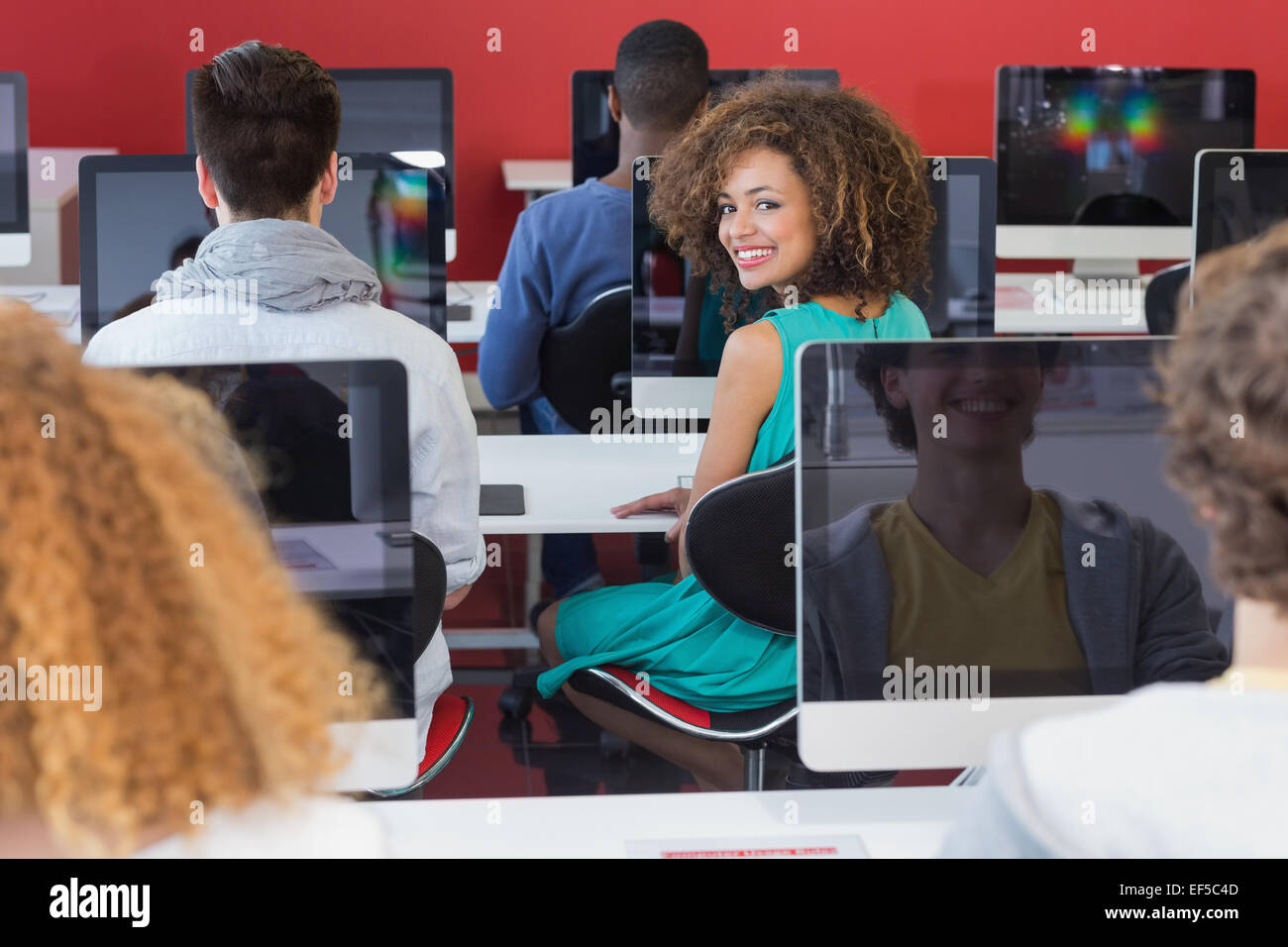 Student smiling at camera in computer class Stock Photo - Alamy