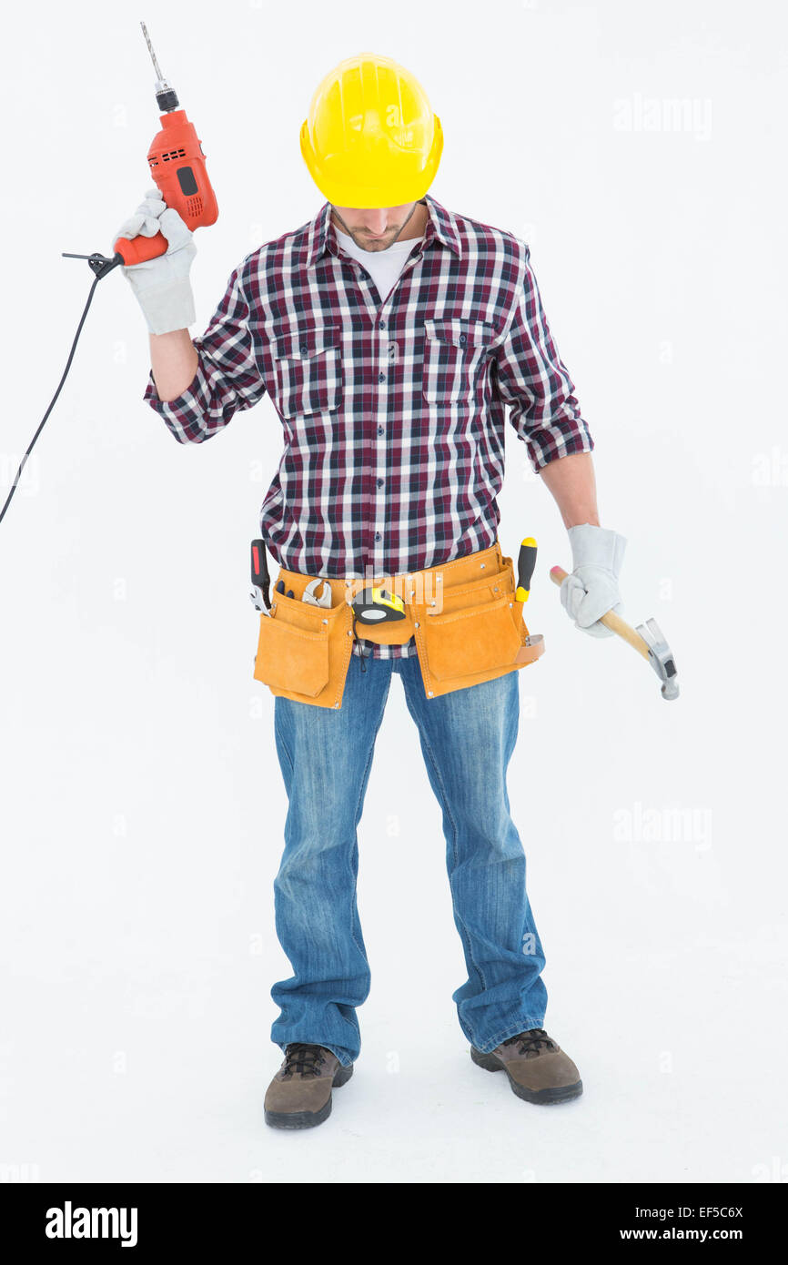 Male repairman holding drill machine and hammer Stock Photo - Alamy