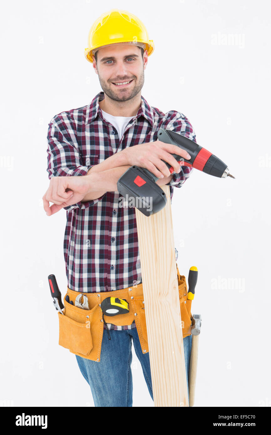 Confident male carpenter with drill machine and plank Stock Photo - Alamy