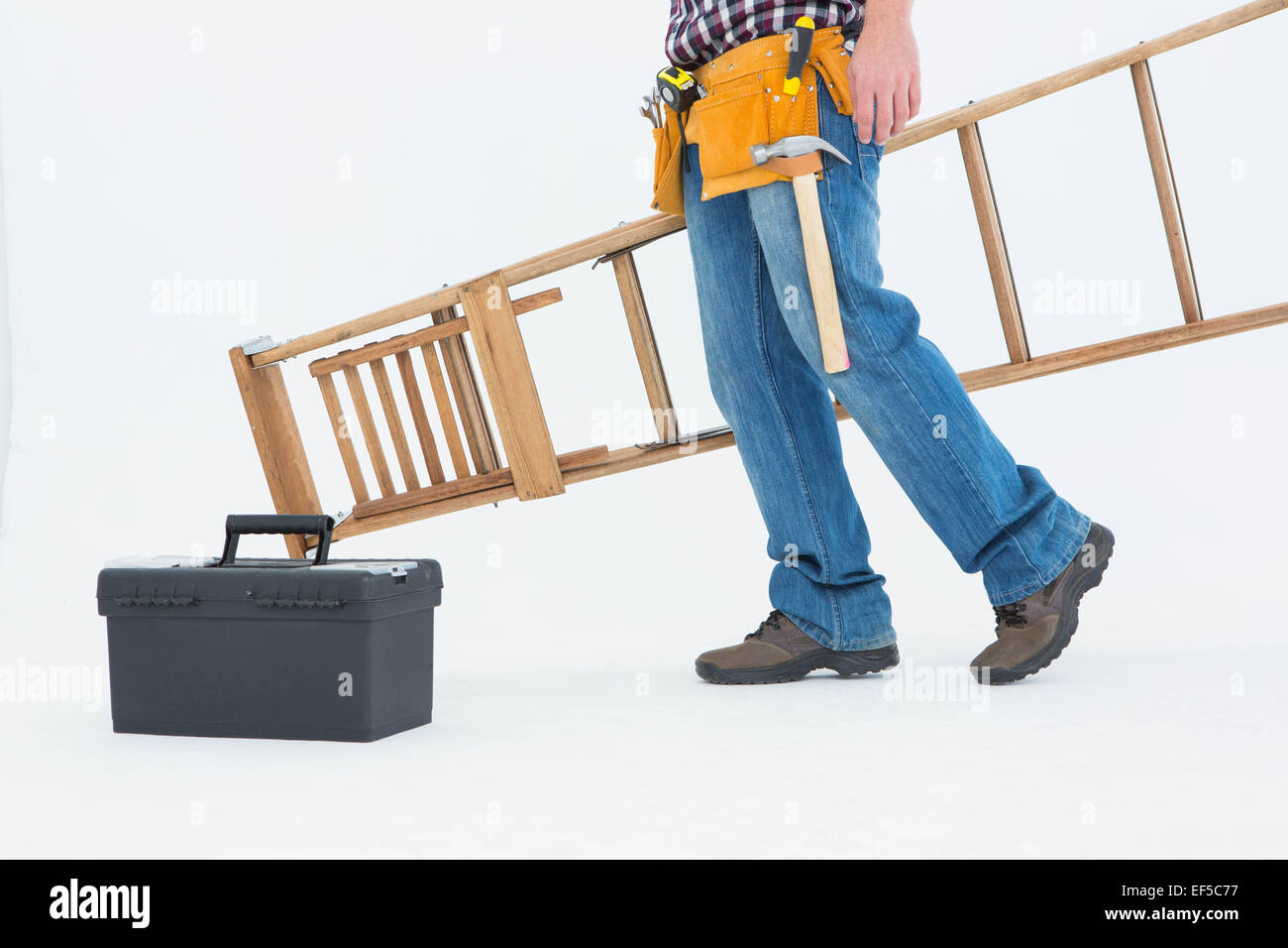 Low section of repairman carrying ladder Stock Photo - Alamy